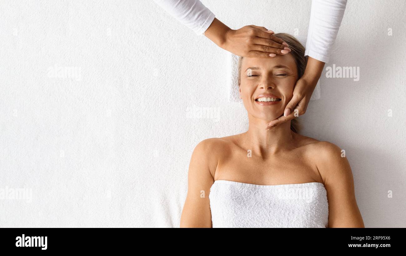 Female therapist making face lifting massage for beautiful woman at spa ...