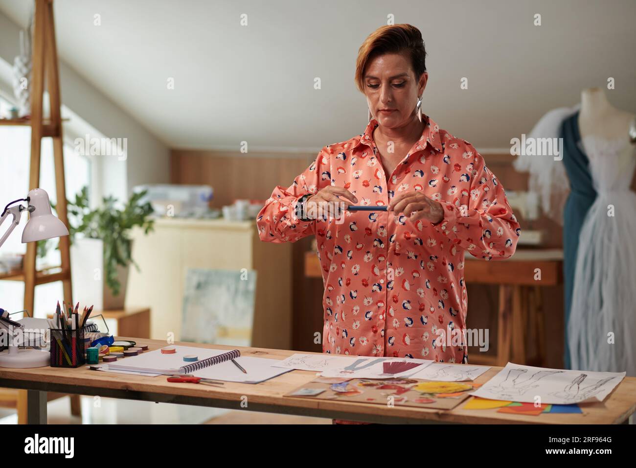 Creative woman photographing cut images she collected for collage Stock ...