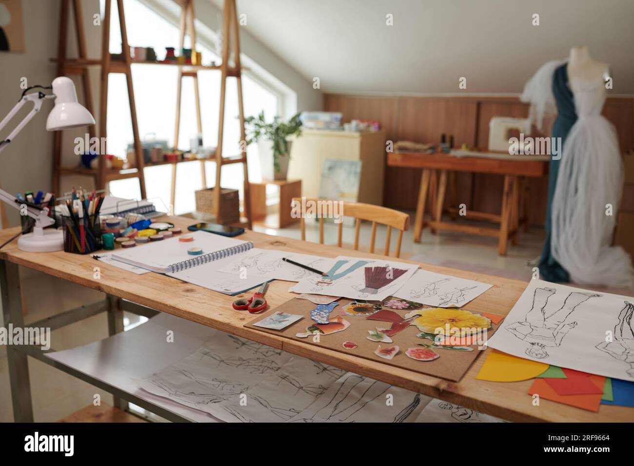 Desk with cut images, stationary and notebooks in studio of ...