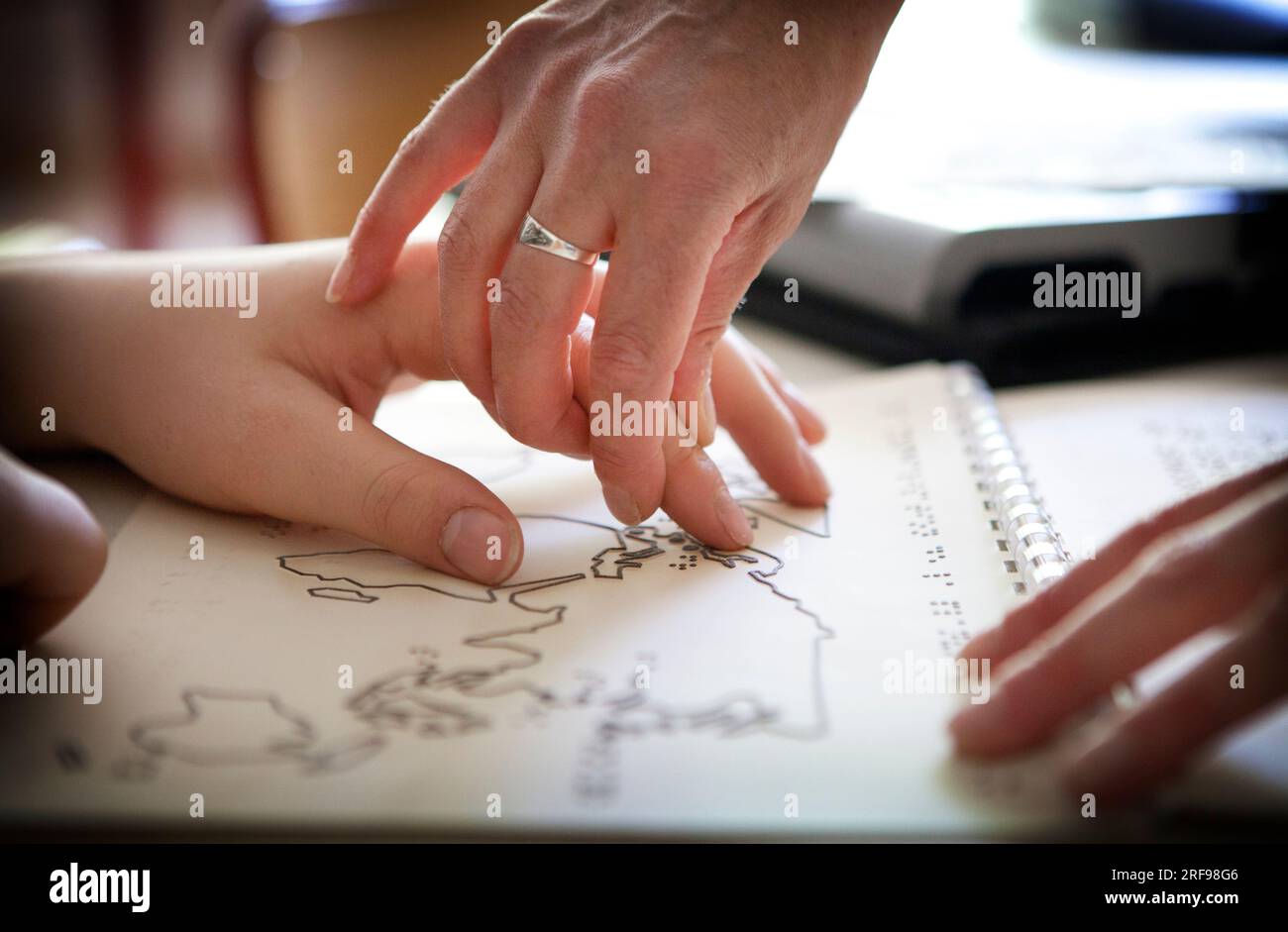 A blind or visually impaired pupil revises the maps in relief to pass ...