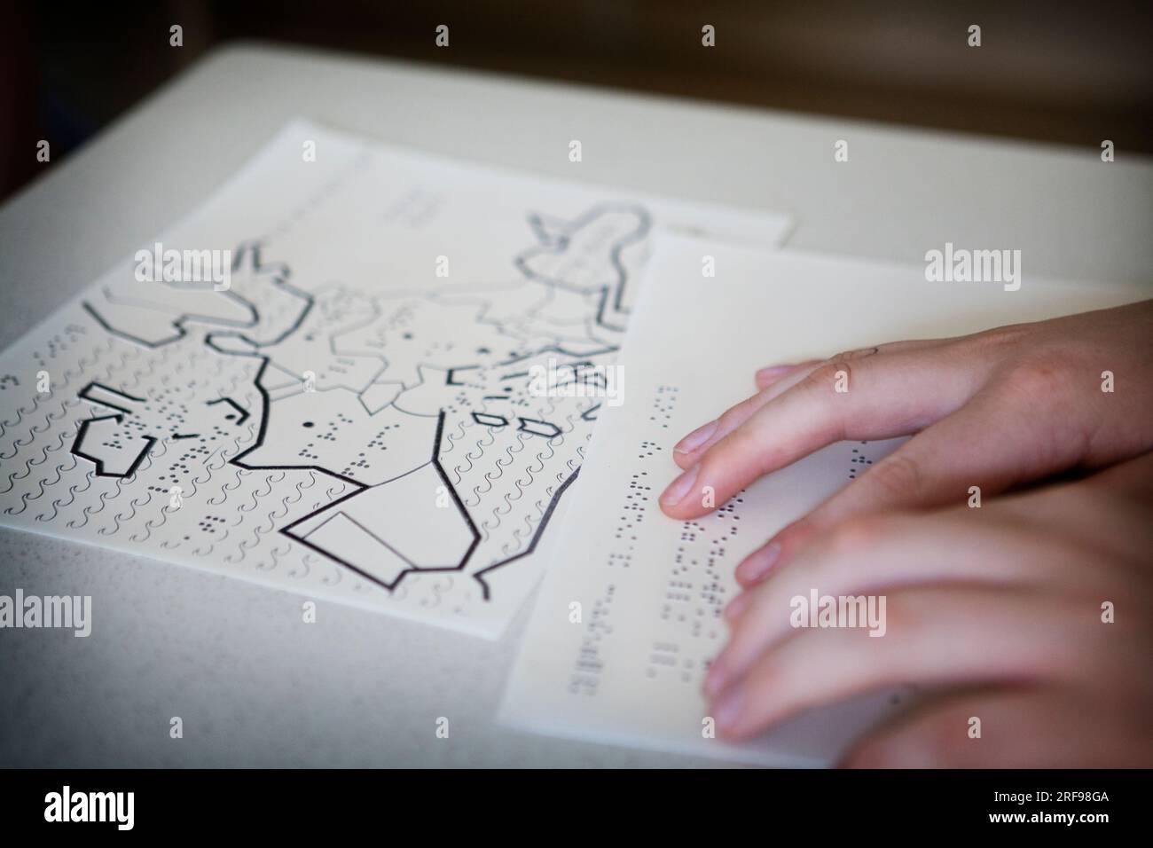 A blind or visually impaired pupil revises the maps in relief to pass ...