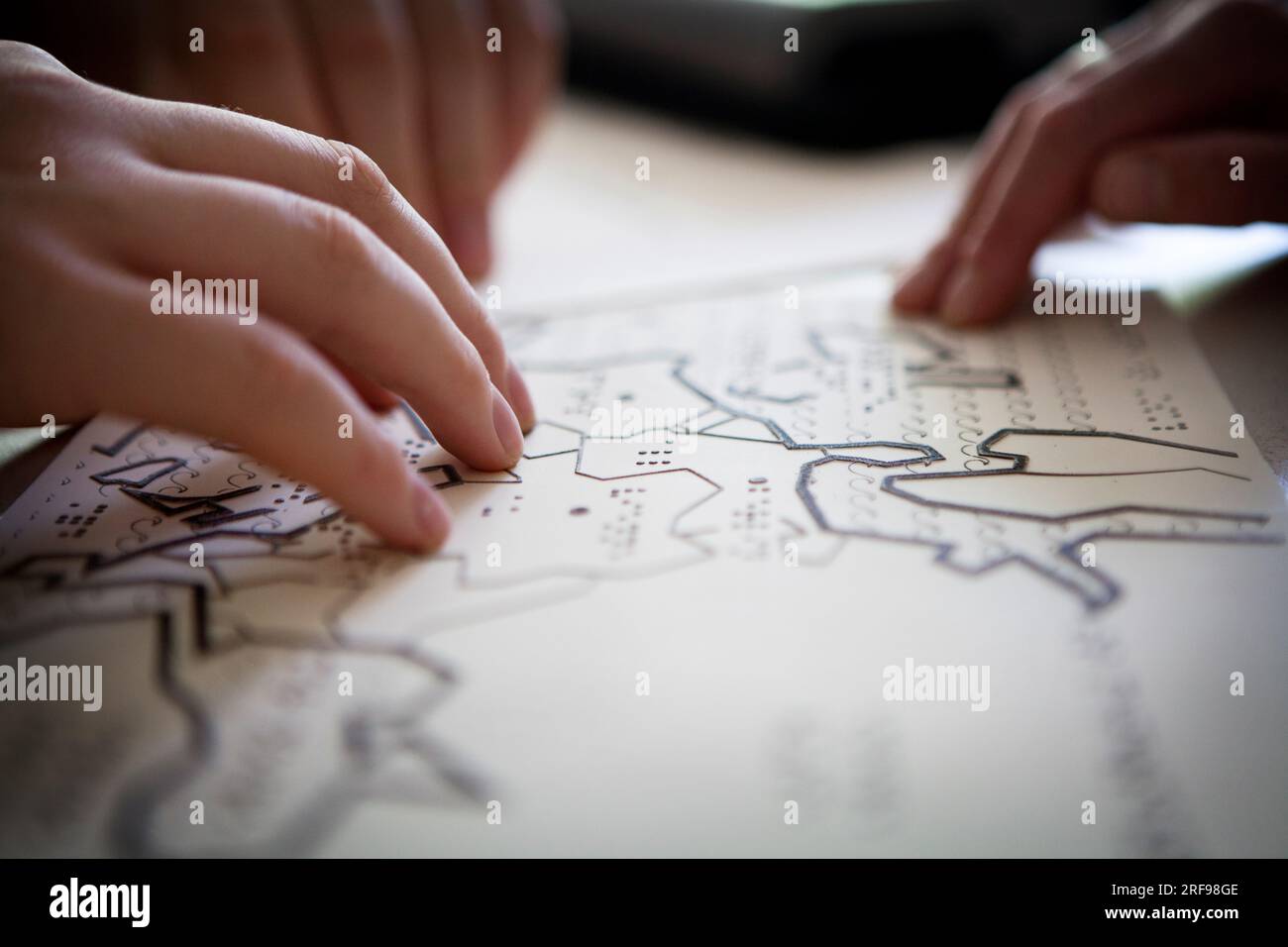 A blind or visually impaired pupil revises the maps in relief to pass ...