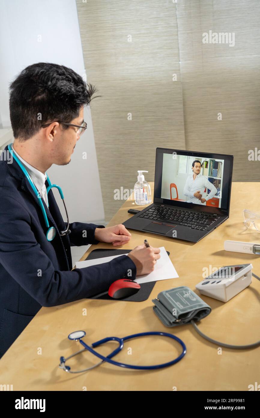 Doctor in remote consultation with 30 year old patient with back pain Stock Photo - Alamy