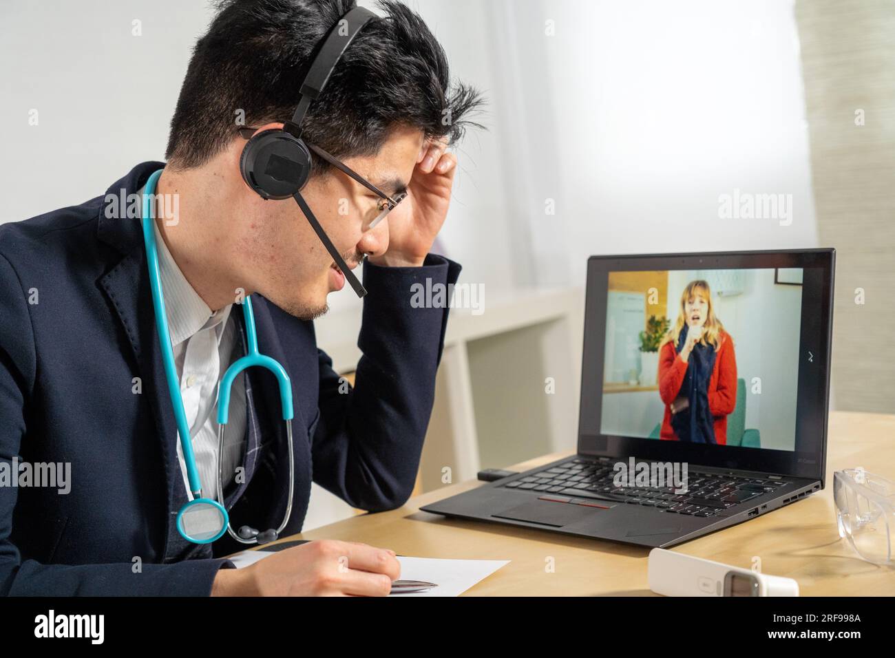 Doctor in remote consultation with a 30-year-old patient with a cold ...
