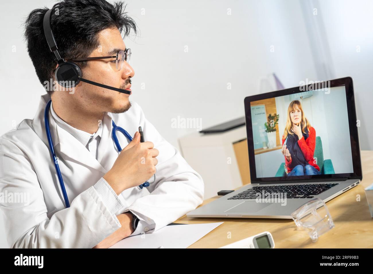 Doctor in remote consultation with 30 year old female patient with pain in her throat Stock ...