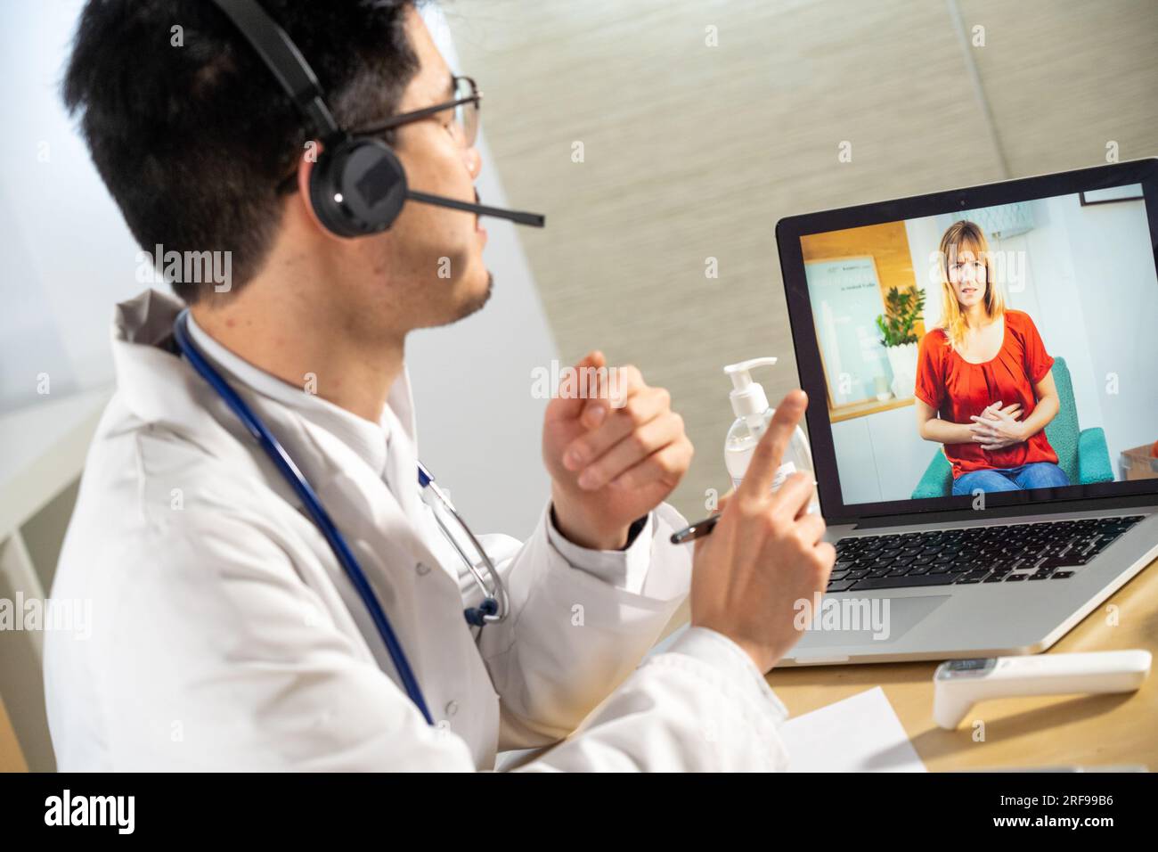 Doctor in remote consultation with 30-year-old female patient with stomach pain Stock Photo - Alamy
