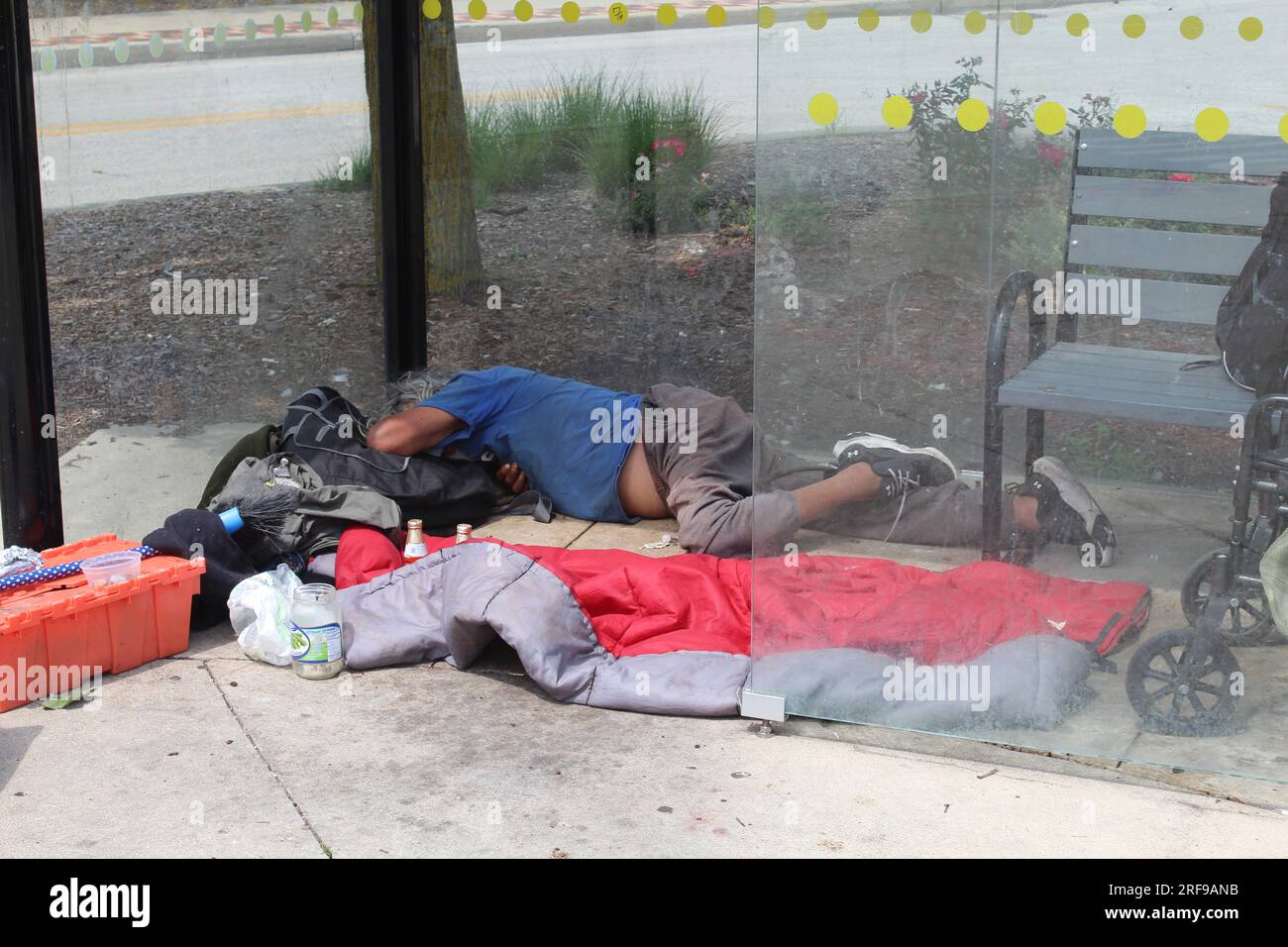 Homeless man sleeping in a bus shelter in Skokie, Illinois Stock Photo ...