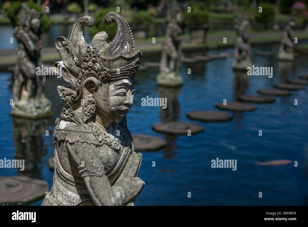 Stone Balinese Statues On Water In The Lake Water Palace Tirta Gangga ...