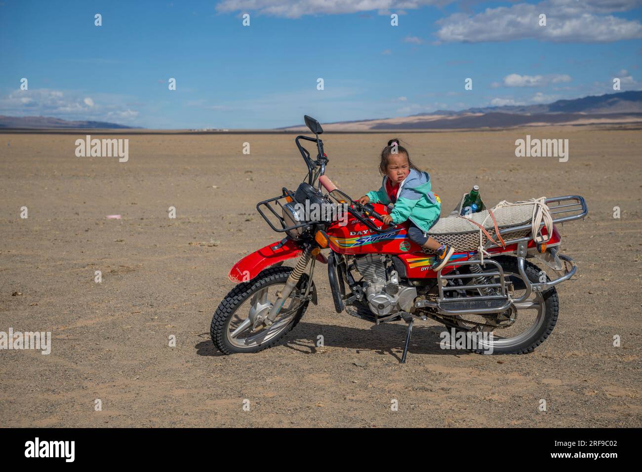 A young girl on a motorcycle at a camel herder s ger near the Hongoryn ...