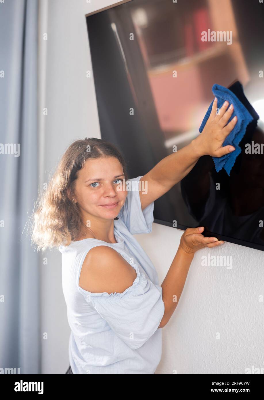 Woman doing housework - washing TV screen with dishcloth Stock Photo ...