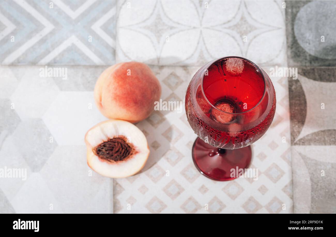 Glass with cold drink and peaches on vintage tile background. Top view ...