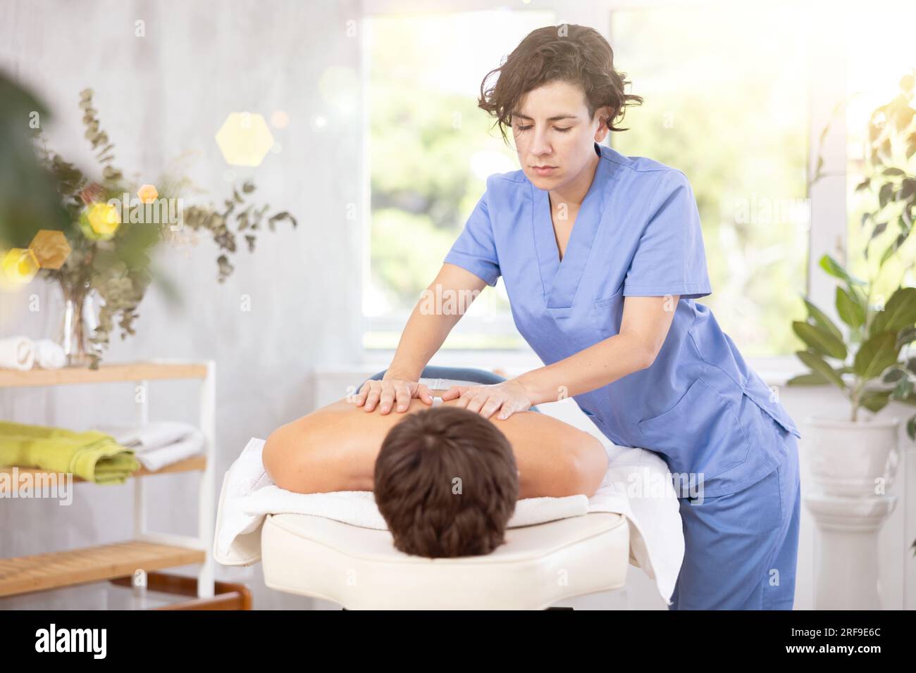 Adult woman giving back massage to young guy Stock Photo - Alamy