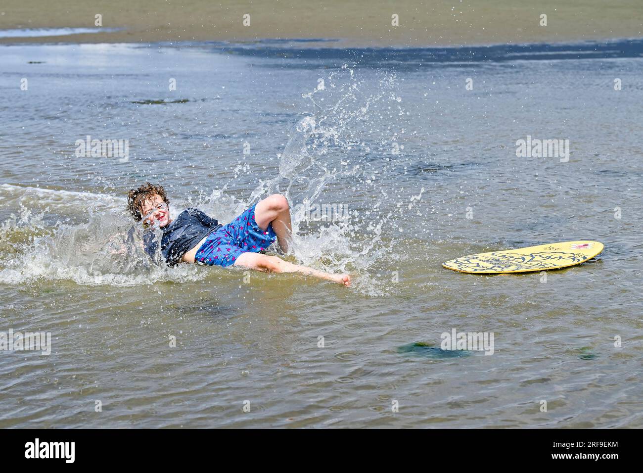 Beach fun, Boy skim boarding at low tide Stock Photo - Alamy