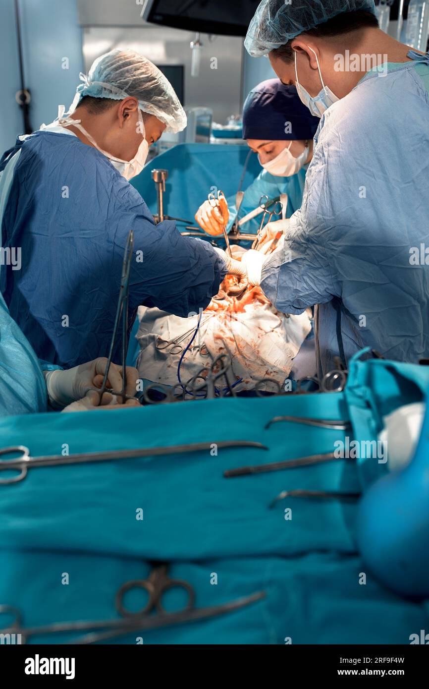 Surgeons team during complex surgical operation in a sterile operating ...