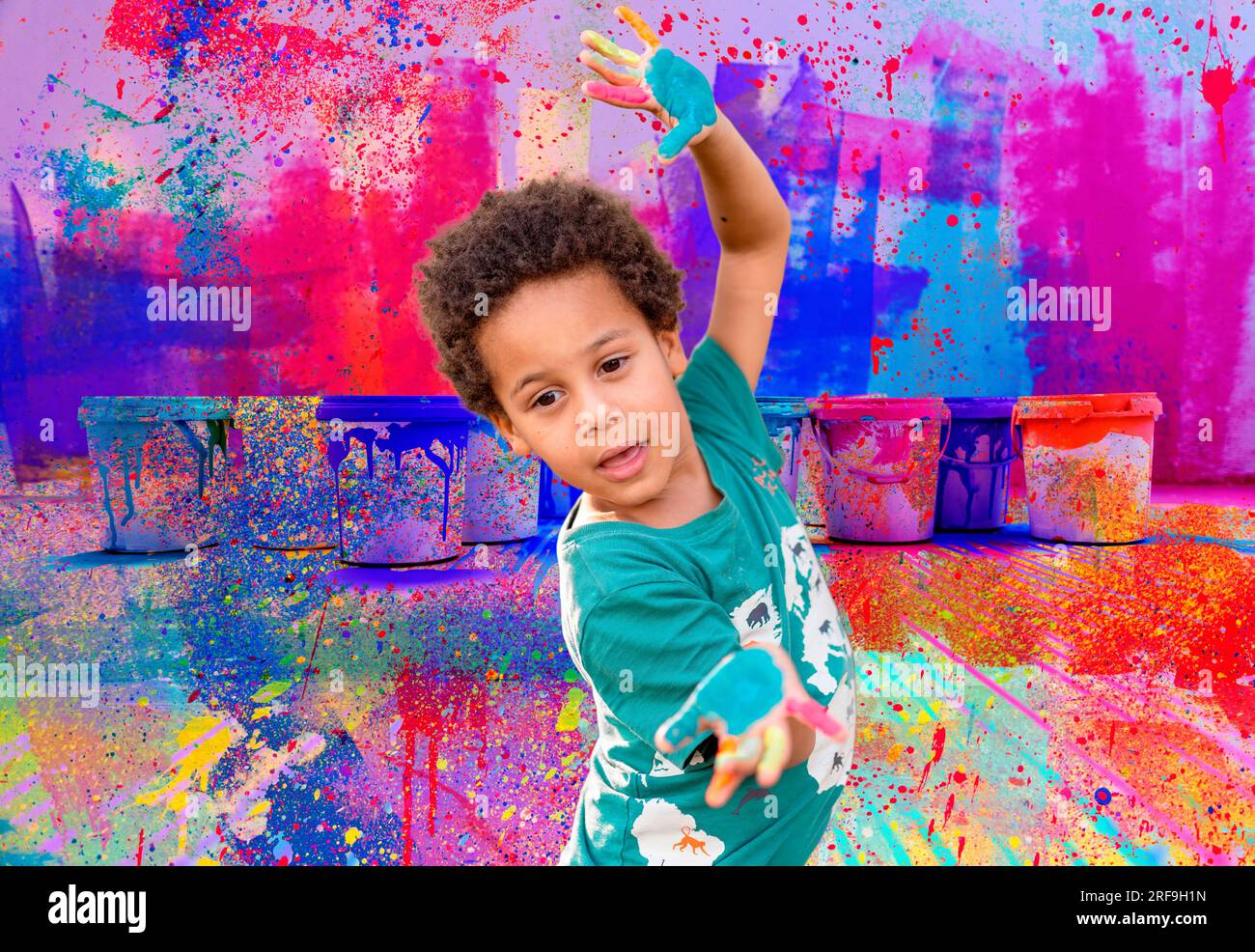 beautiful happy boy with painted hands over a colorful painted brush ...