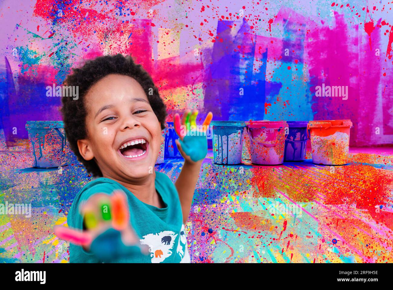 beautiful happy boy with painted hands over a colorful painted brush ...