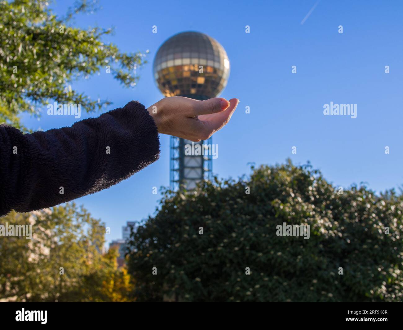 An enchanting illusion: a female hand holds the golden globe of ...