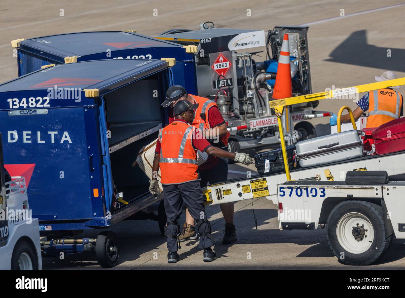 Men working to claim baggage for an airplane are seen at the Dallas ...