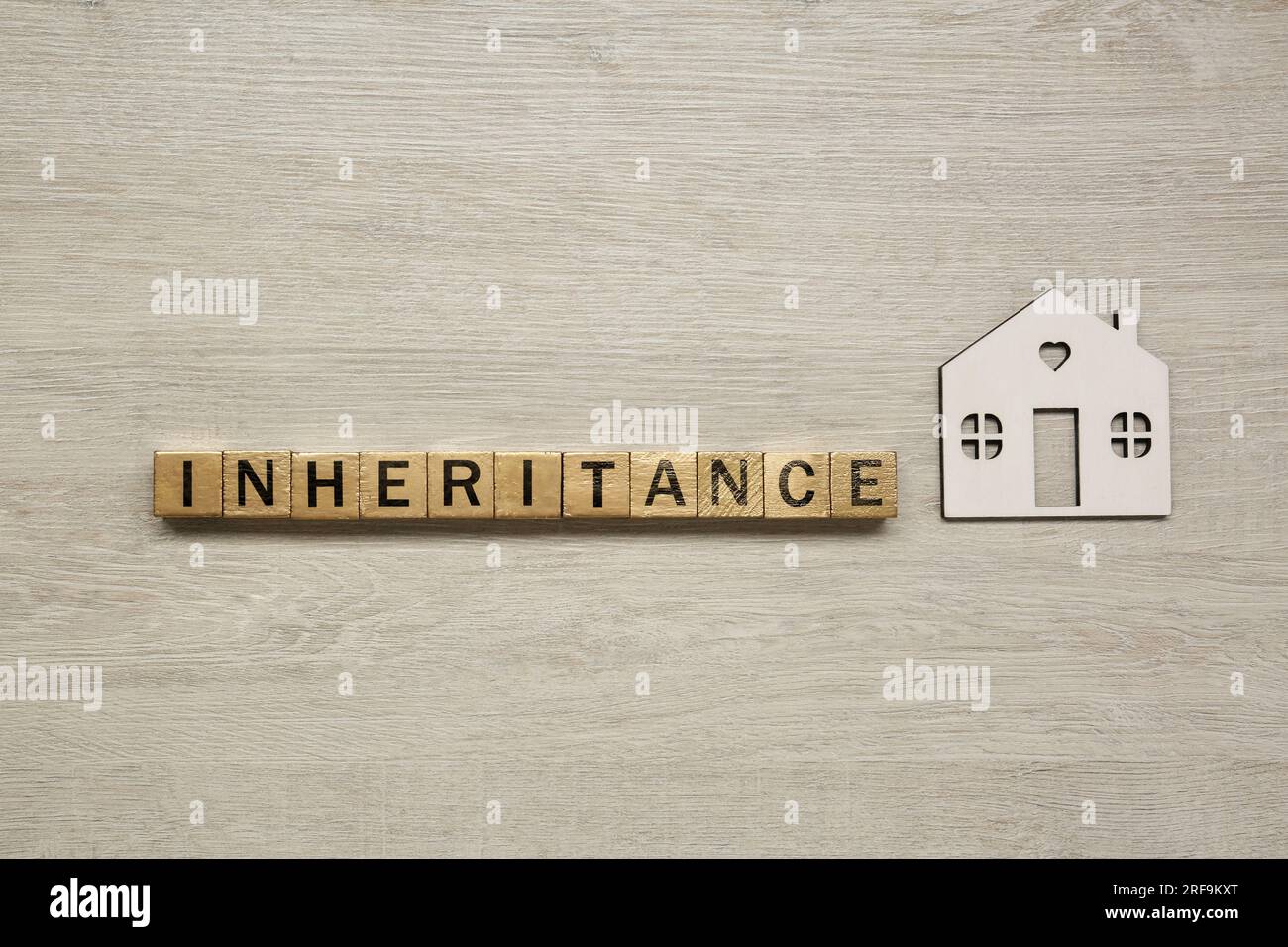 Word Inheritance made with cubes and house model on light wooden ...