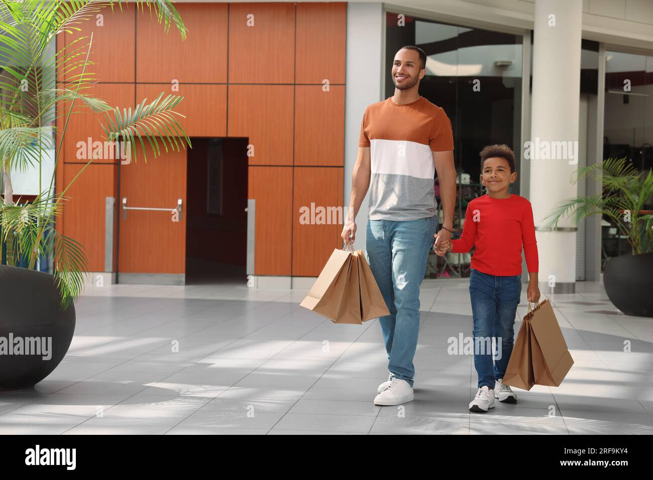 Family shopping. Happy father and son with purchases in mall Stock ...