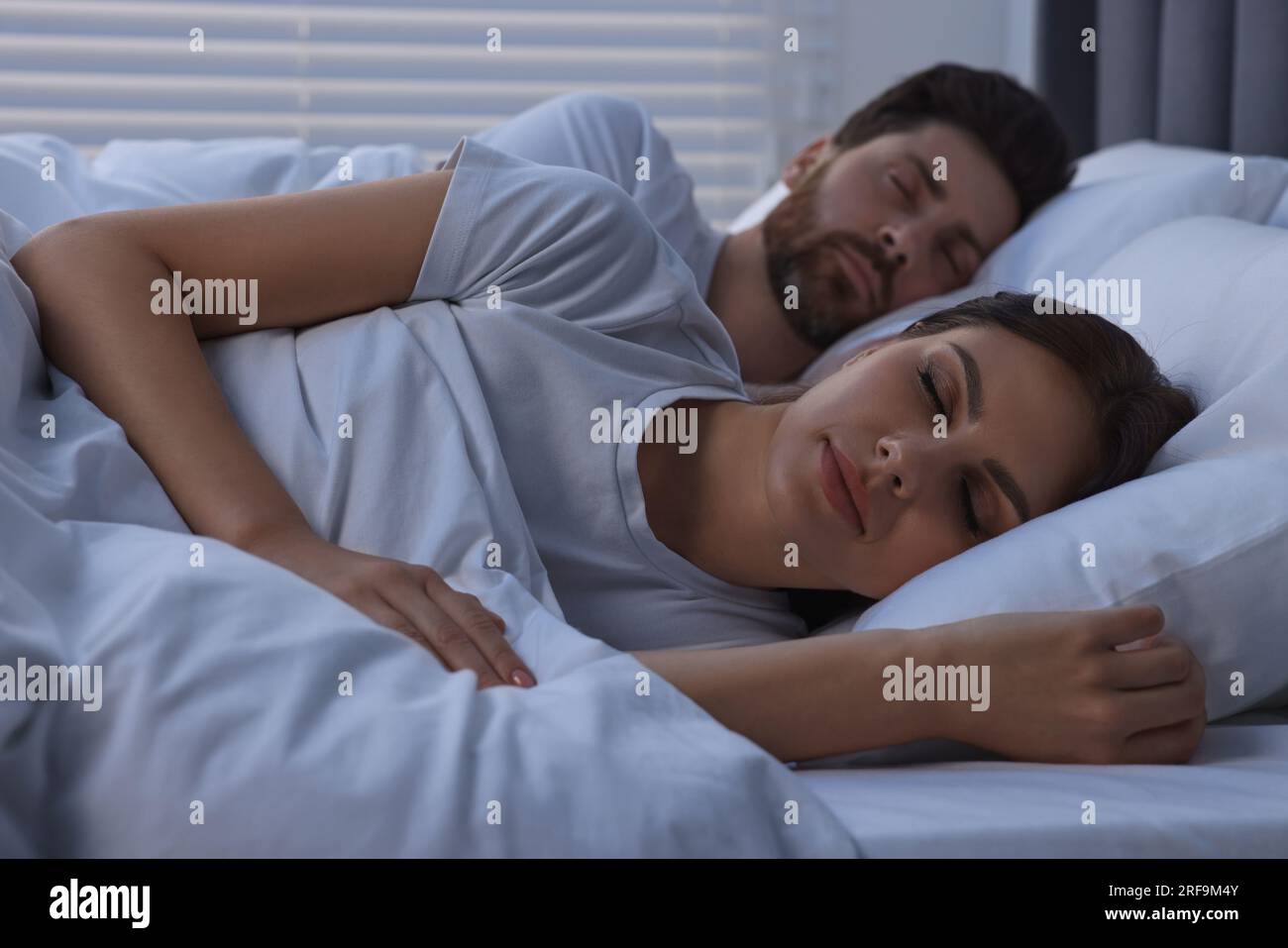 Lovely couple sleeping together in bed at night Stock Photo - Alamy
