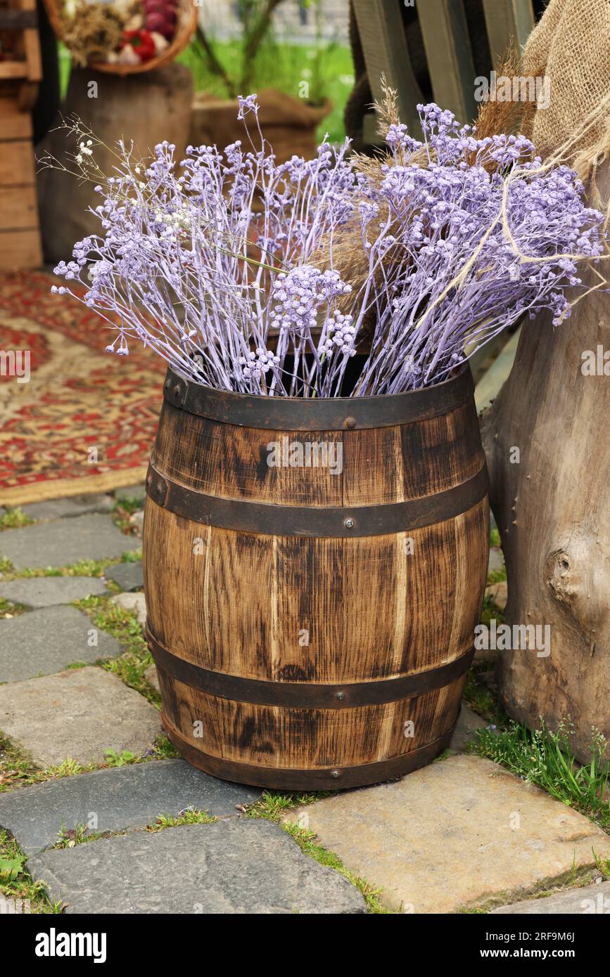 Traditional wooden barrel and beautiful decorative branches outdoors ...