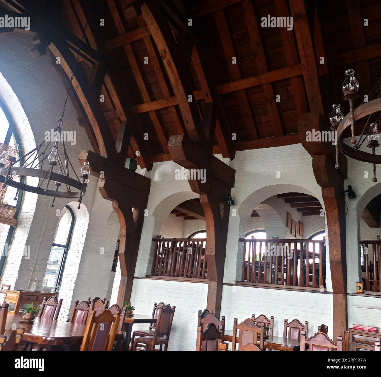 Empty restaurant with very elegant wooden tables, beamed ceiling, huge ...
