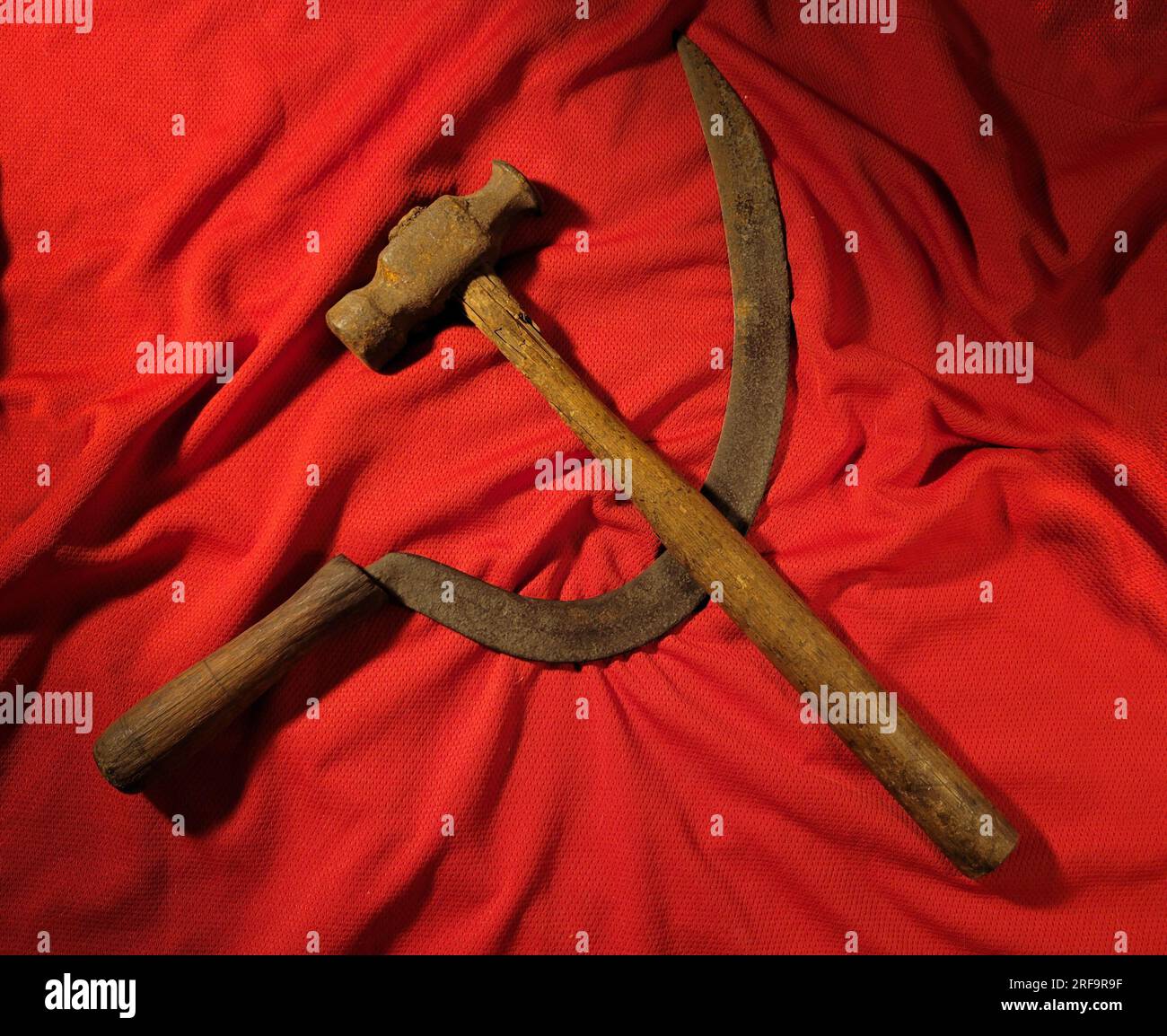 Antique hammer and sickle on red cloth form the symbol of the former ...