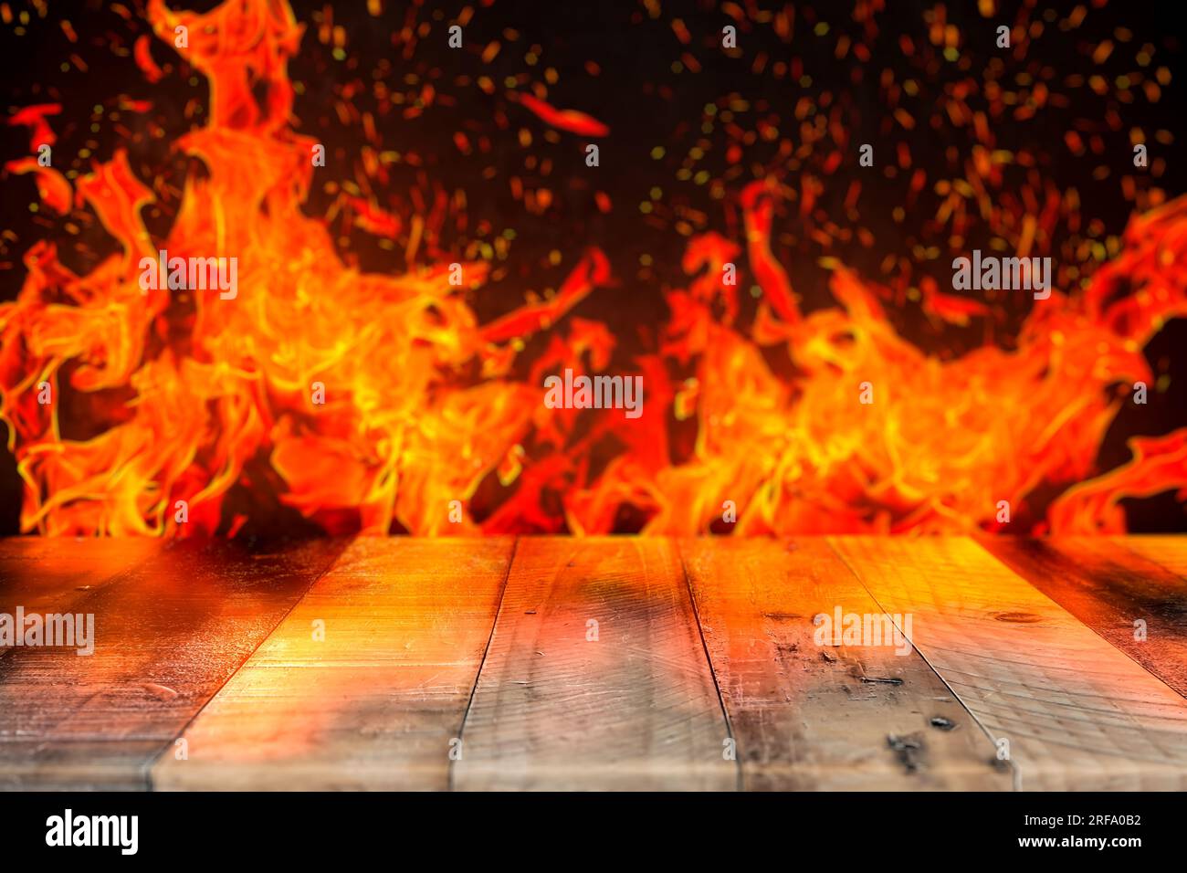 Rustic wooden table with flames and fire effect on dark blurred ...
