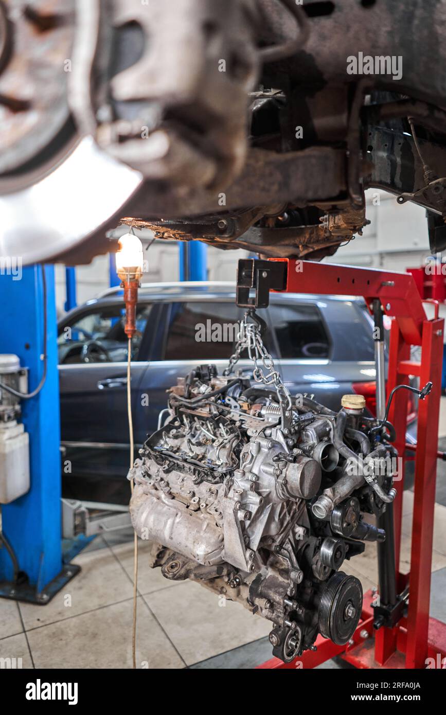 A car mechanic inspects the engine with a flashlight. Engine Block on a ...