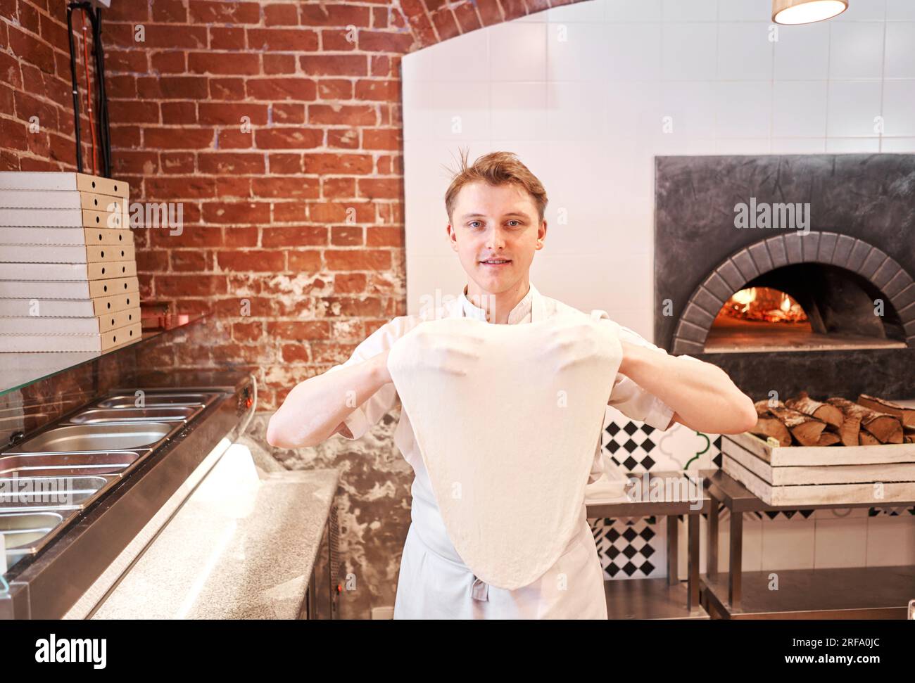 The chef prepare pizza. Raw pizza ready to bake. Cook in a apron in the ...