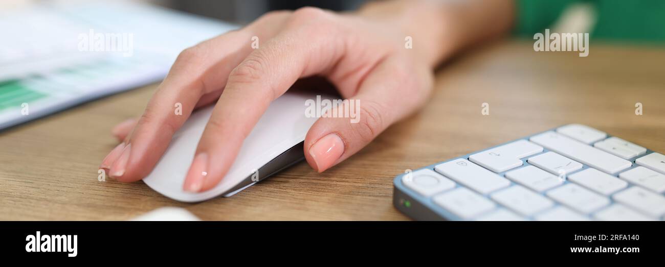 Close-up of business woman's hand holding computer mouse on office desk ...