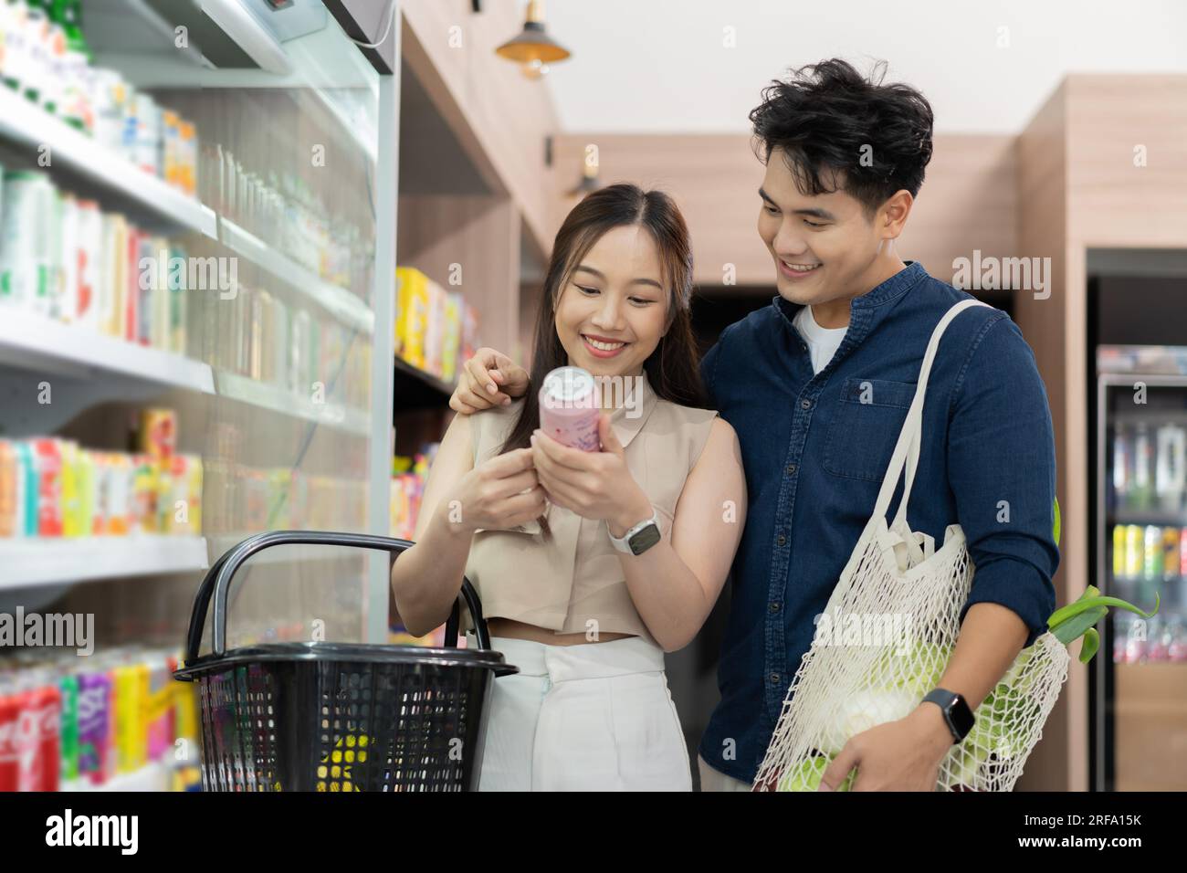 Millennial Asian couple family shopping groceries in supermarket buying ...