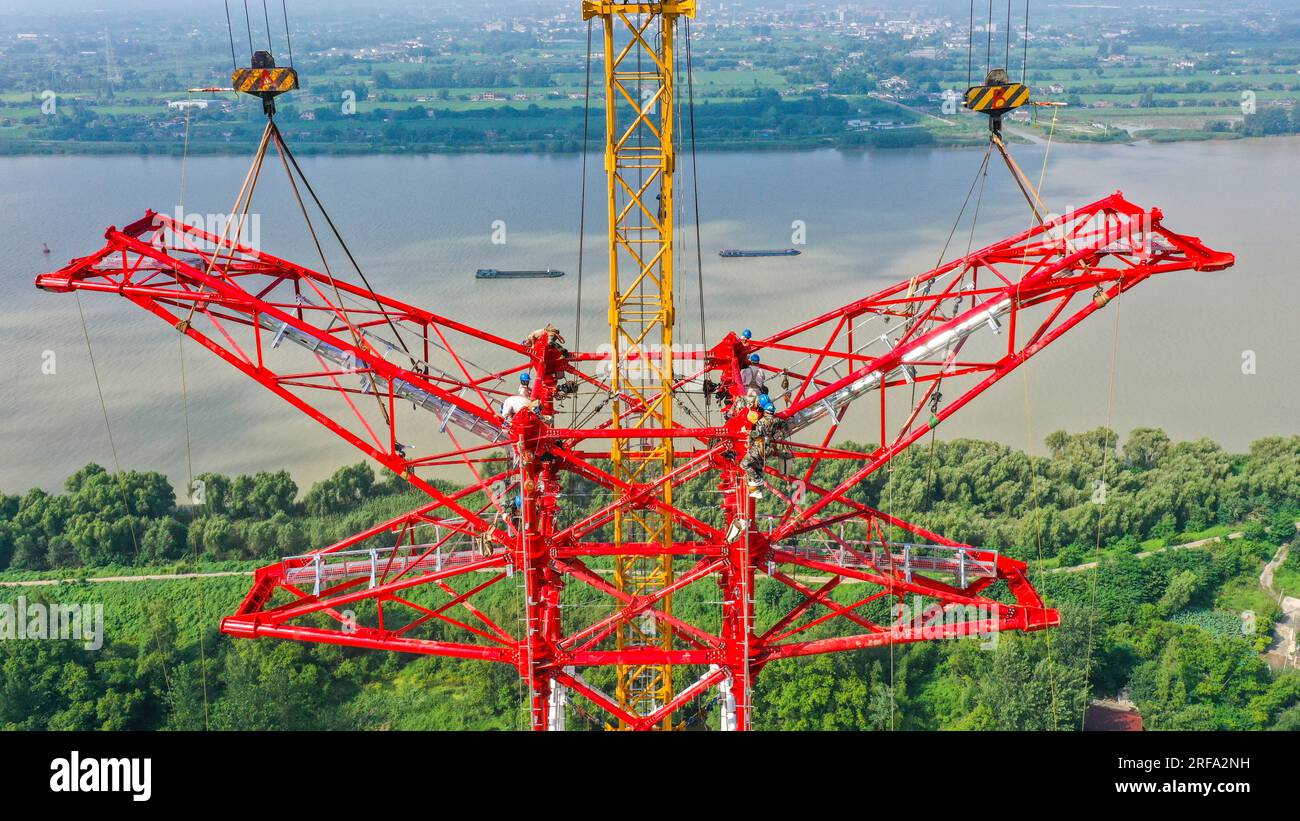 YANGZHOU, CHINA - AUGUST 2, 2023 - Construction workers assemble a steel tower at an altitude of ...