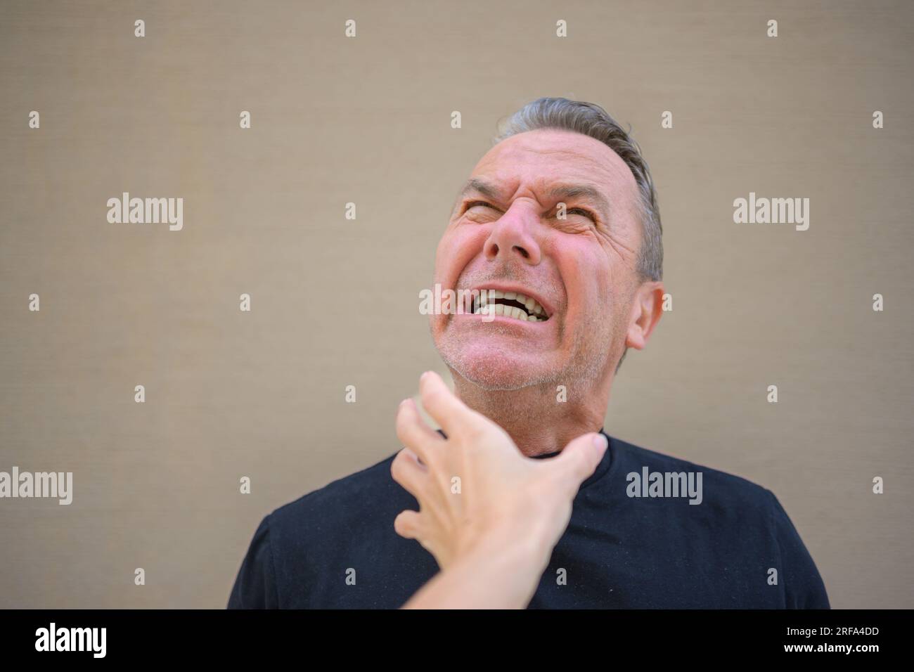 Attractive man screams while stranger's hand is on his neck Stock Photo ...