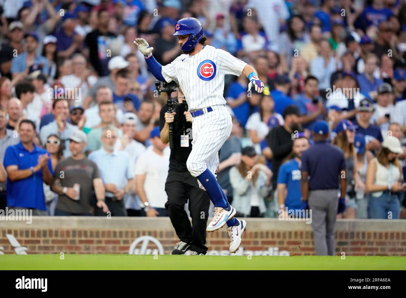 Chicago Cubs' Dansby Swanson leaps into the air as he scores on his ...