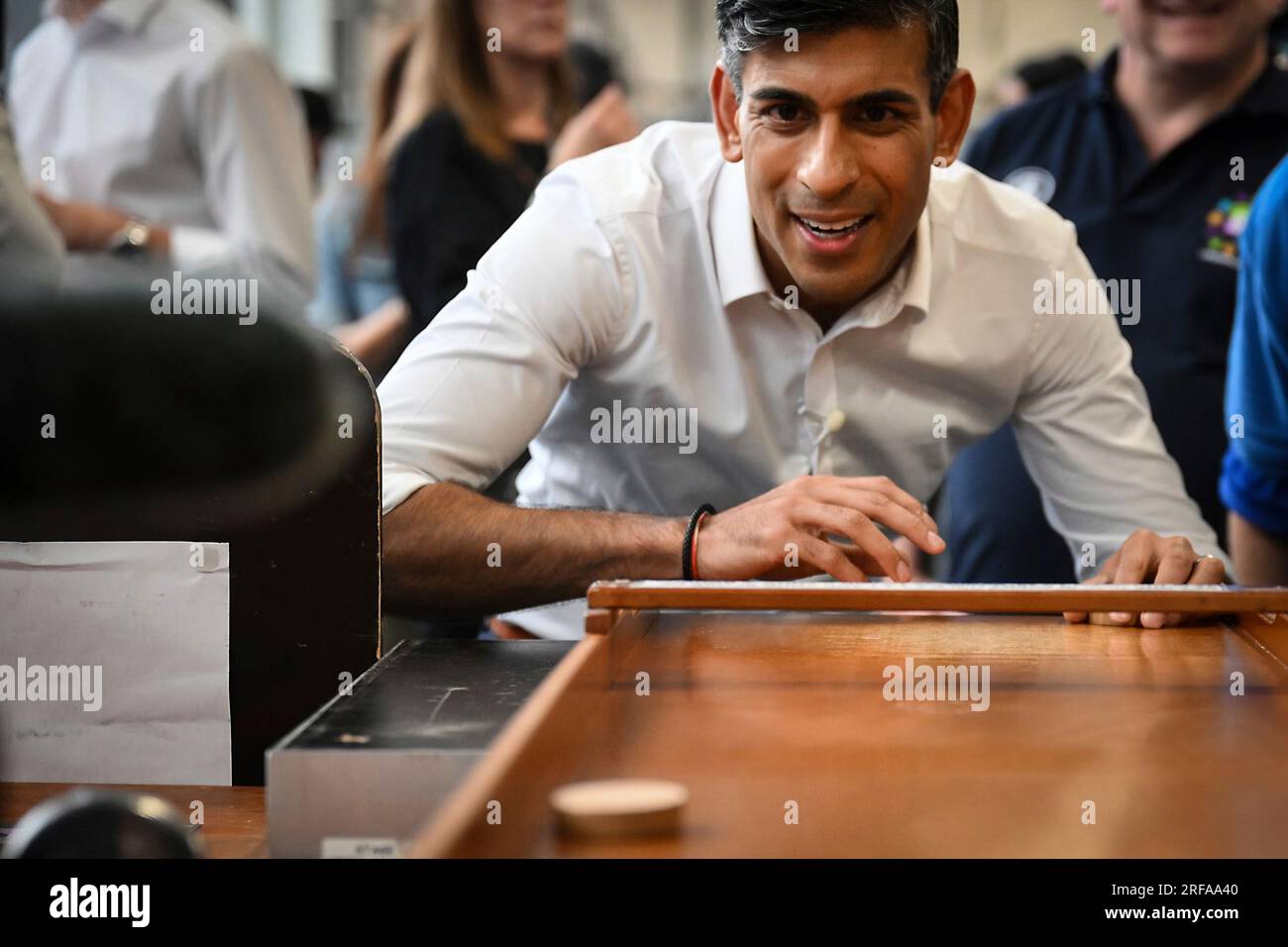 Britain's Prime Minister Rishi Sunak reacts as he plays a pub game ...