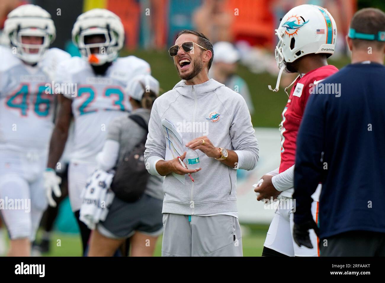 Miami Dolphins head coach Mike McDaniel, left, laughs as he talks with ...