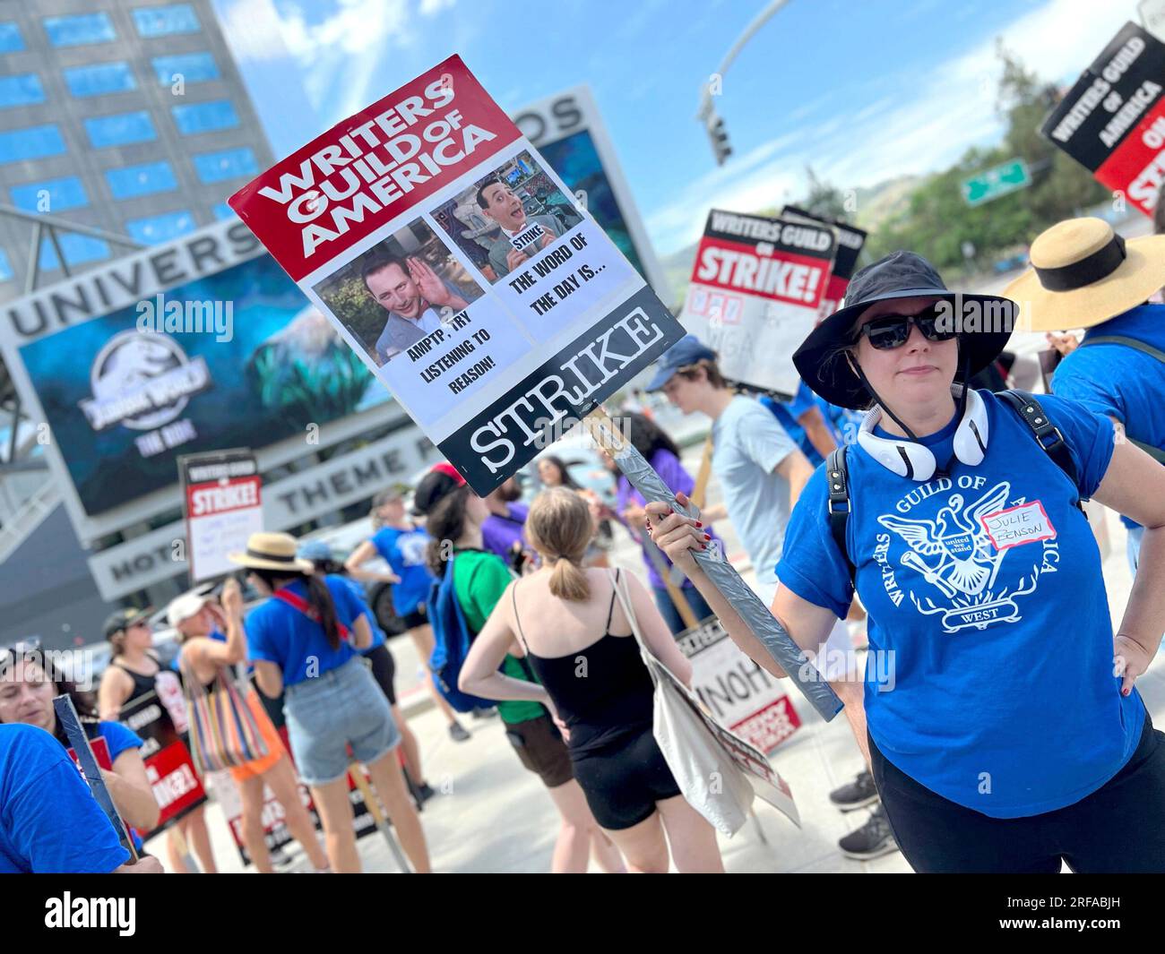 Writer Julie Benson holds a picket sign with an image of the late actor ...