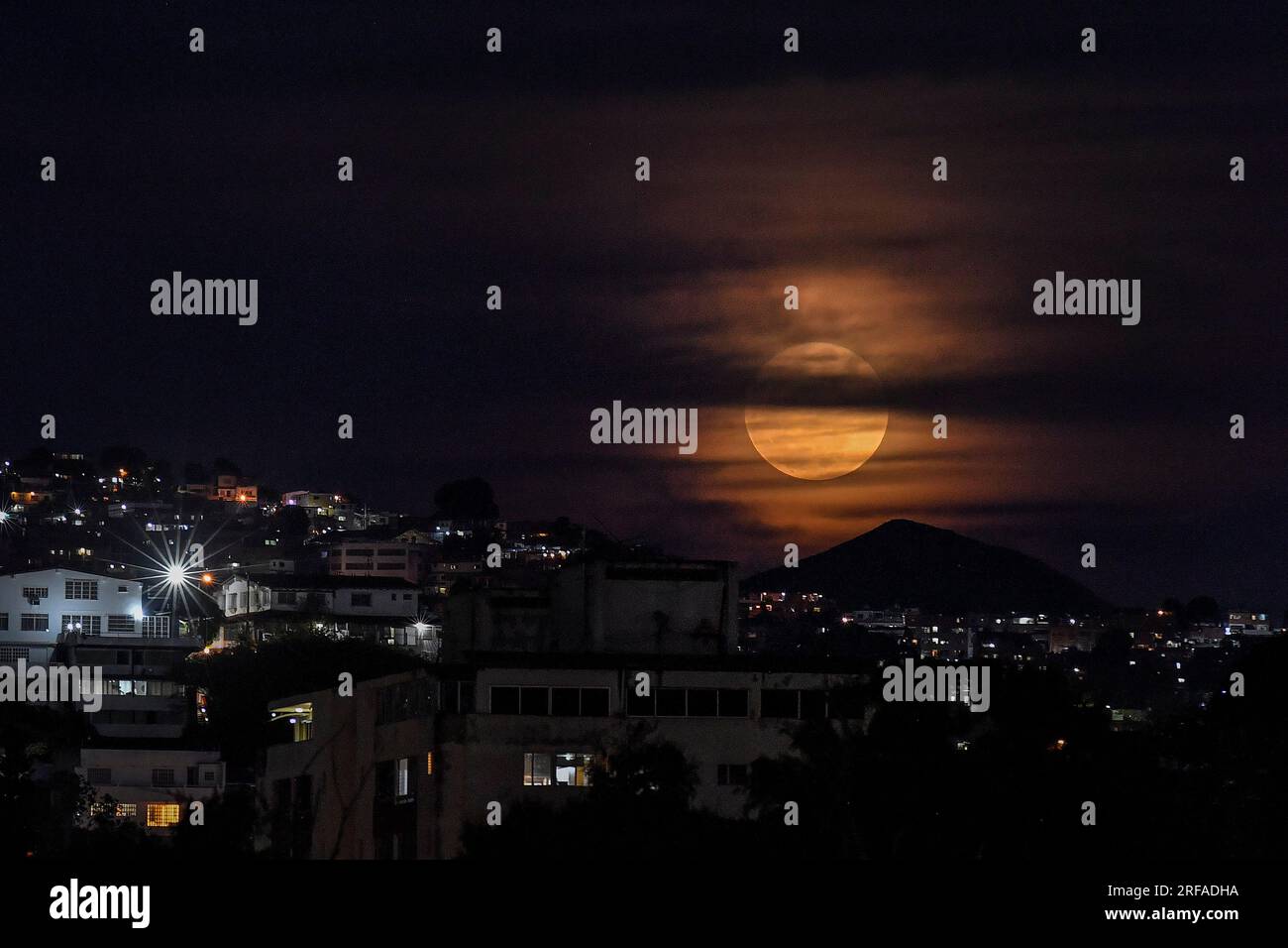 The full moon rises over the Petare neighborhood of Caracas, Venezuela ...
