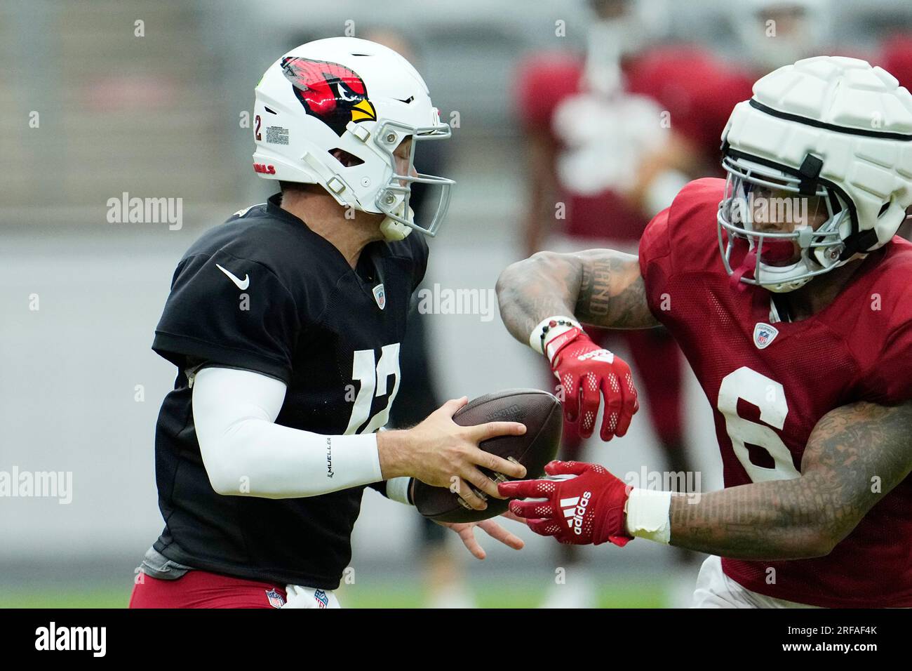 Arizona Cardinals quarterback Colt McCoy, left, fakes a handoff to ...