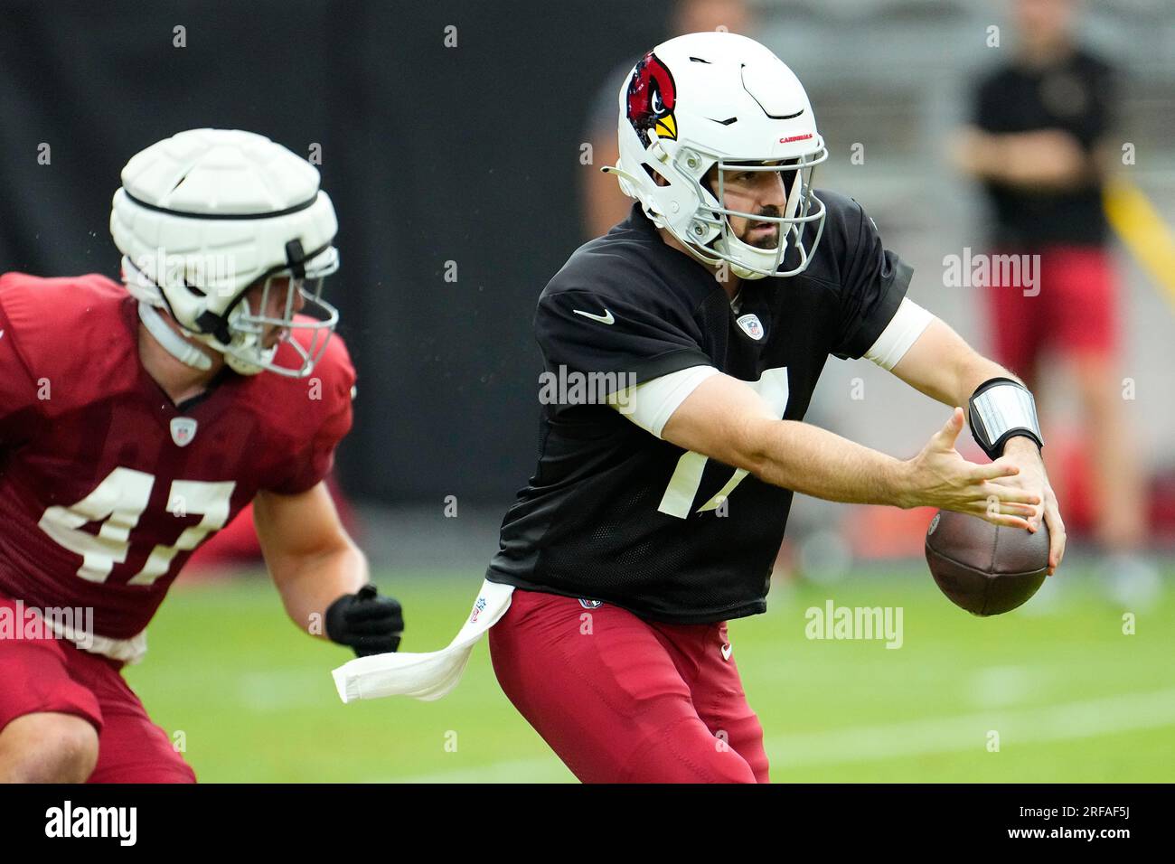 Arizona Cardinals quarterback David Blough, right, fakes a handoff as ...