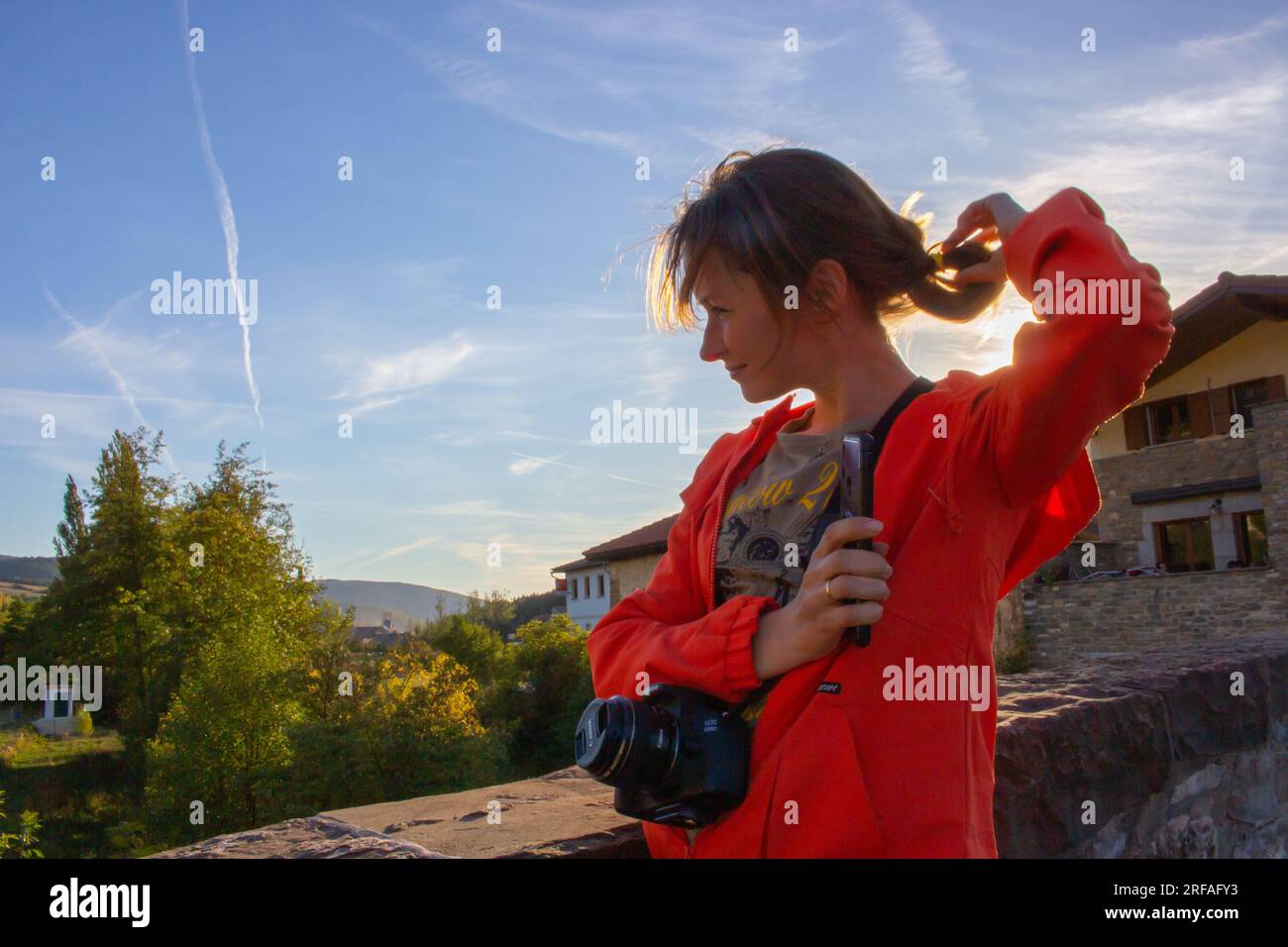 Cute girl with camera. Beautiful photographer on the wind. Happy ...