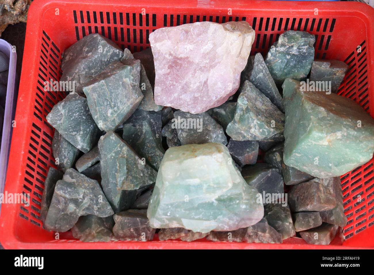 Different coloured natural rock and stones kept in a basket at street ...