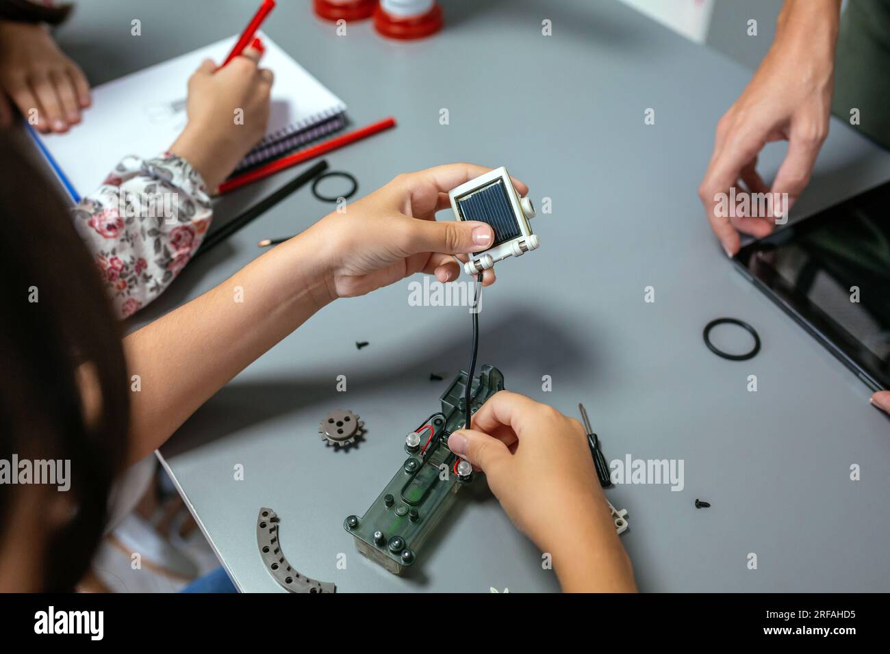 Unrecognizable female student connecting solar panel to electrical ...
