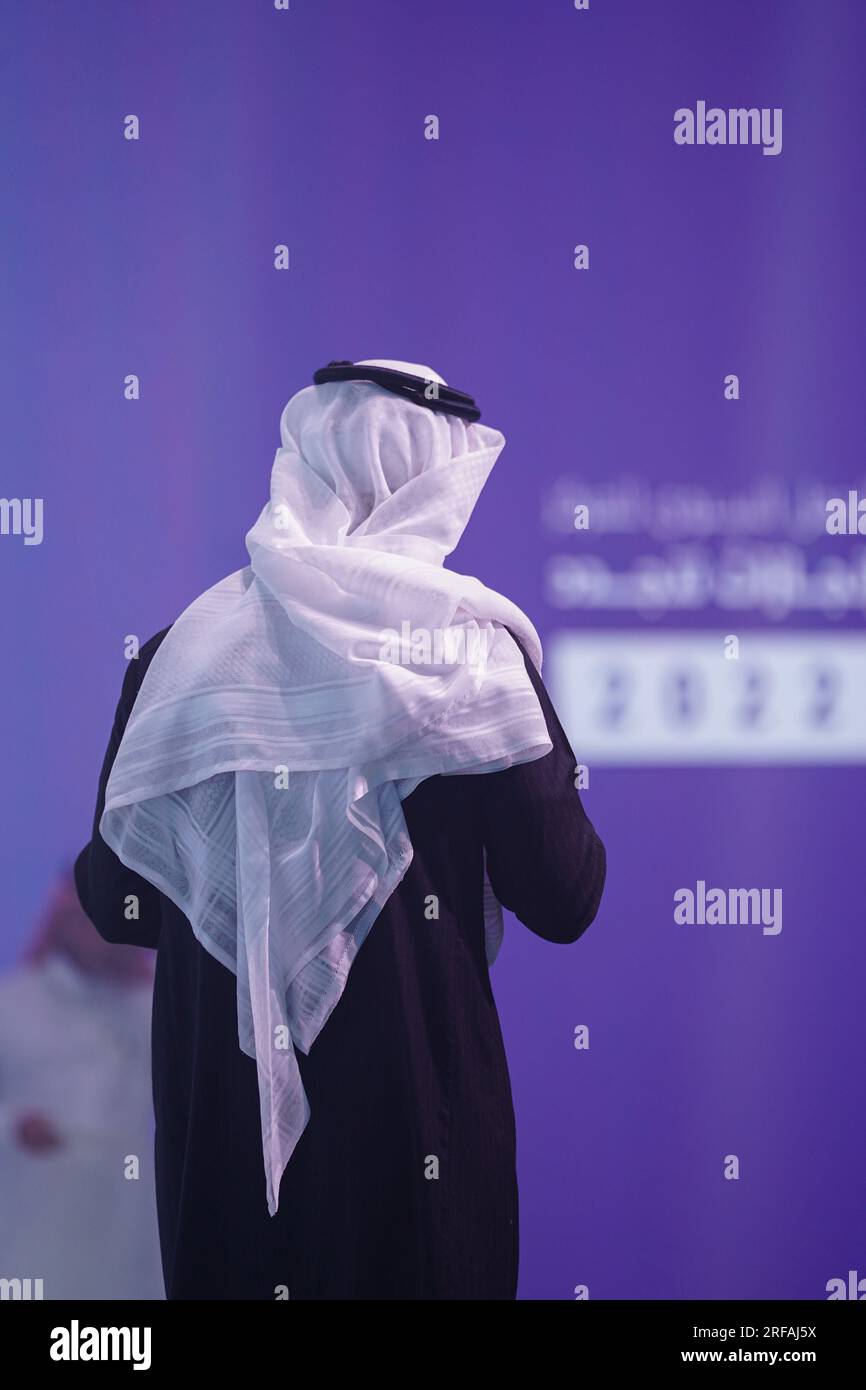 A Saudi Arabian Gulf man from behind, explaining on a large screenA ...
