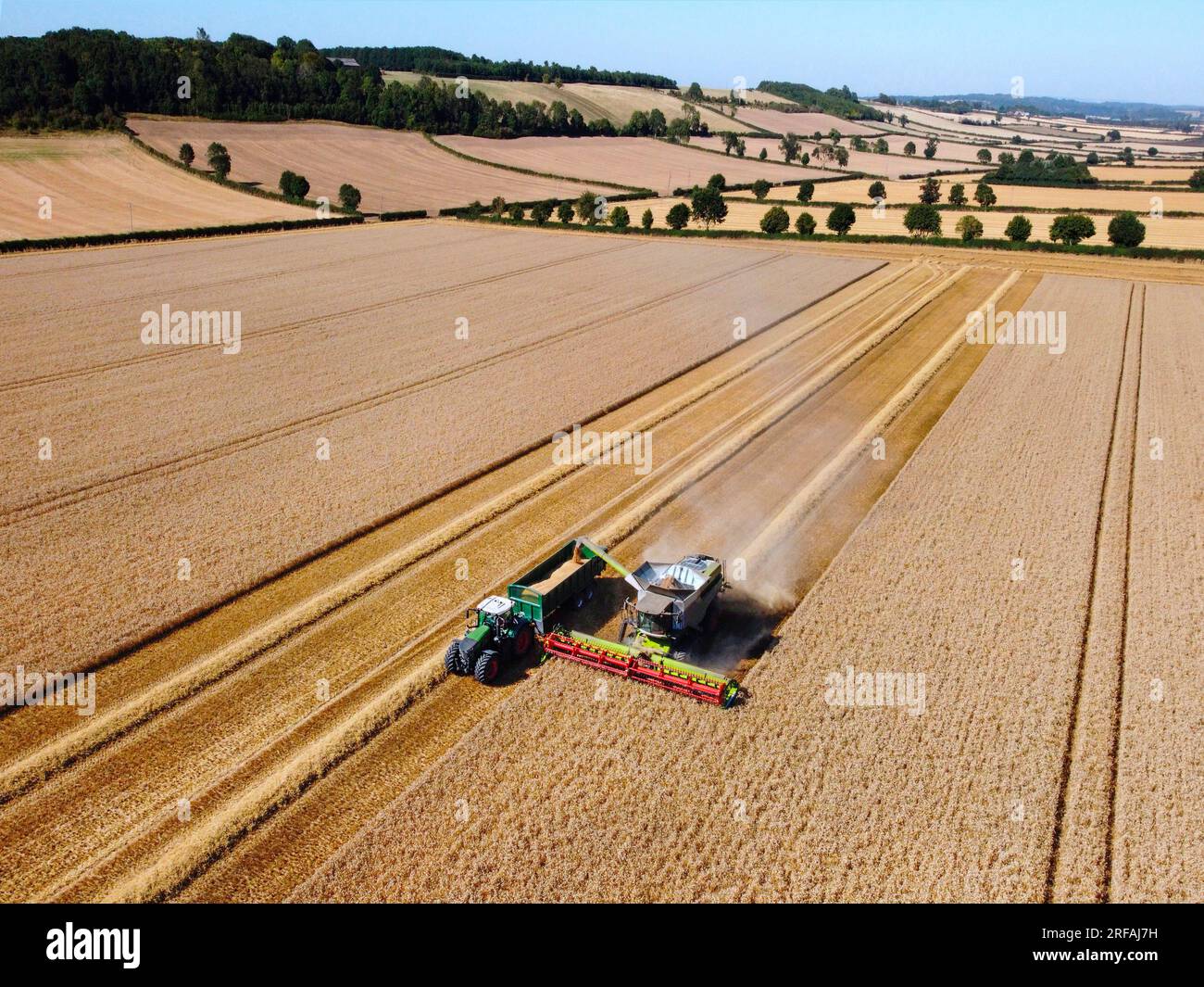 Aerial view of a combine harvester working in a landscape of wheat ...