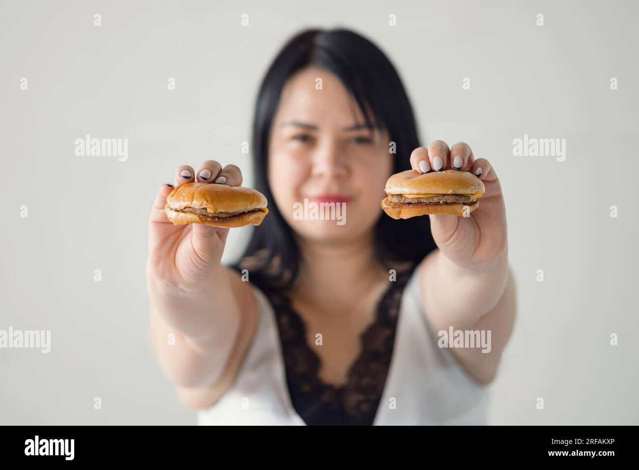 Adult woman shows tasty burgers from fast food restaurant Stock Photo ...