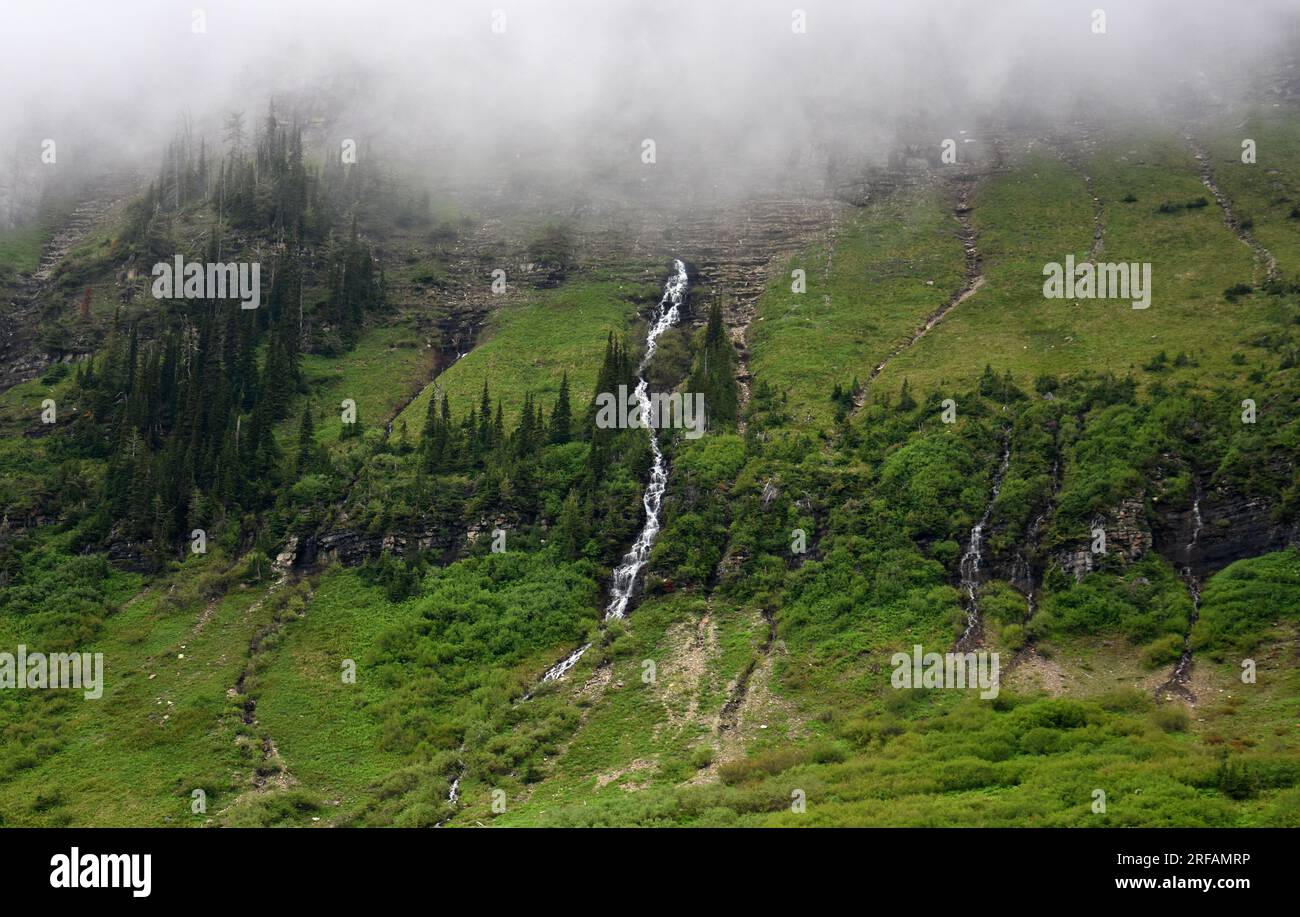 a pretty waterfall on a steep, green hillside along the going-to-the ...