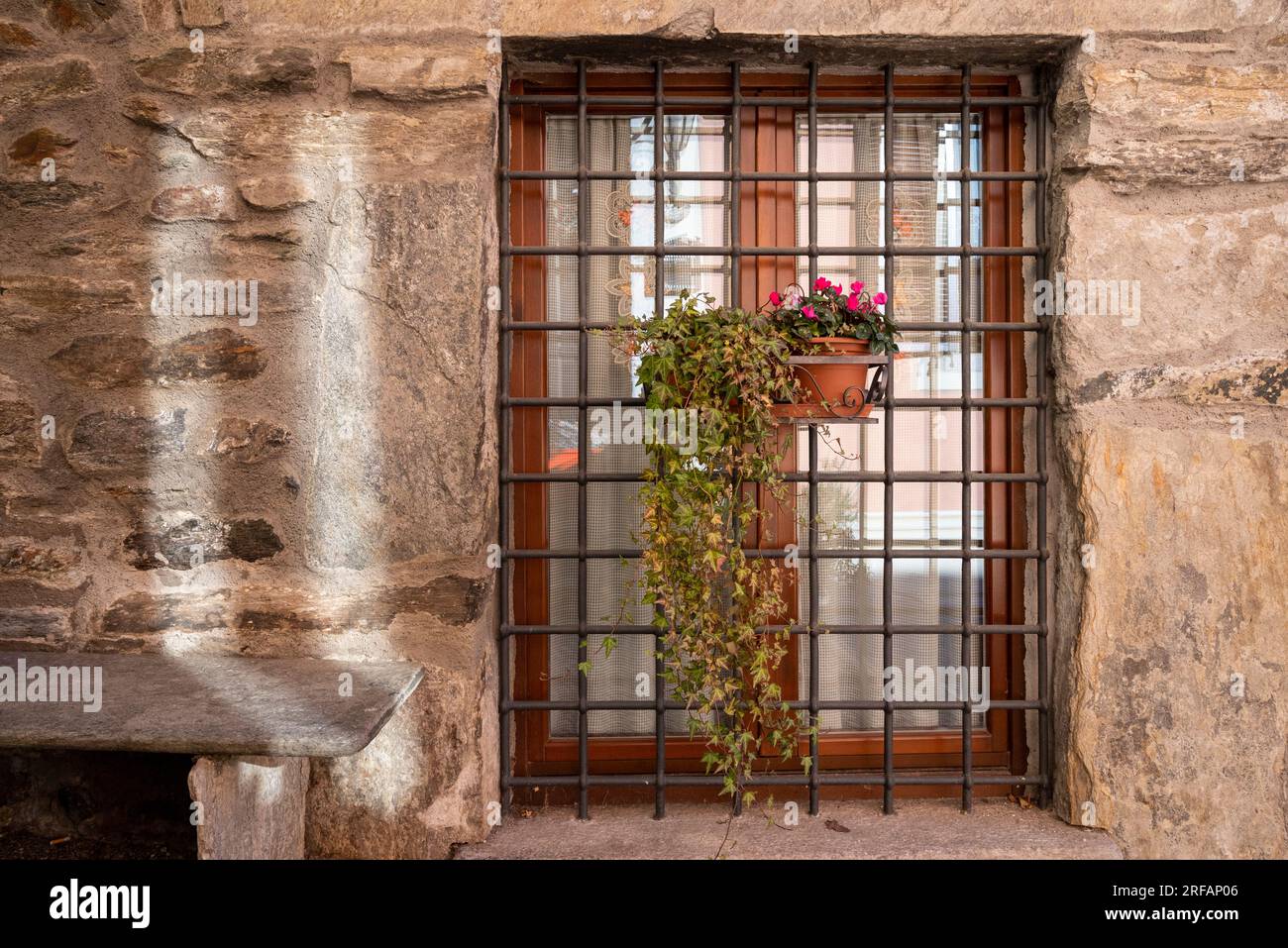 Ancient window with grate and flower pot in historic Italian village ...